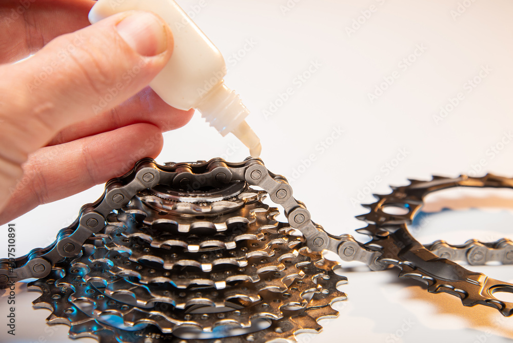 Oiling the bicycle chain with an oiler. Care of the bicycle's drive ...