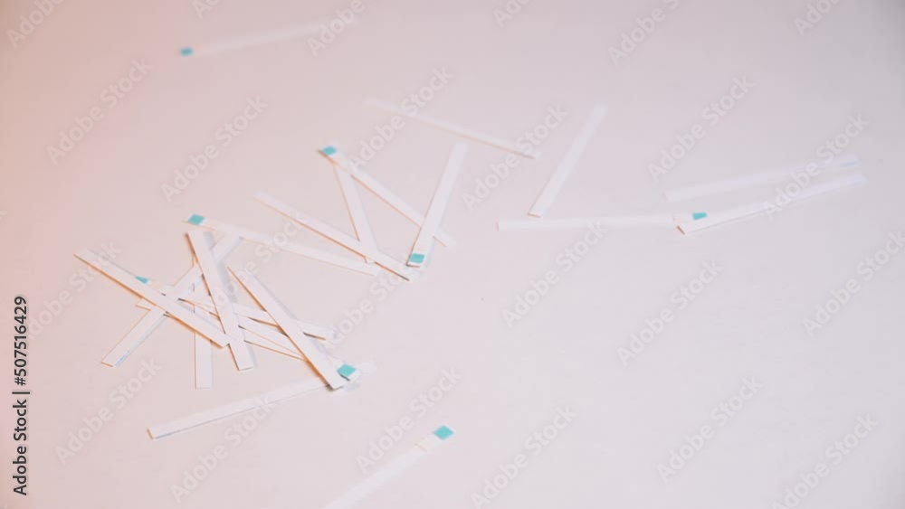 Disposable test strips with litmus papers fall on white background ...