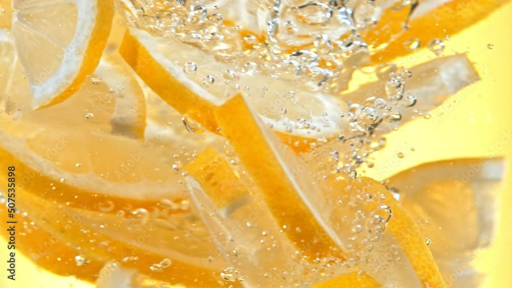 Super Slow Motion Shot of Fresh Lemon Slices Falling into Water Vortex ...