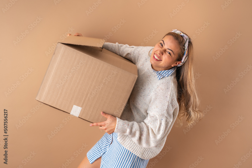 Beautiful attractive young woman posing happily and holding a heavy ...