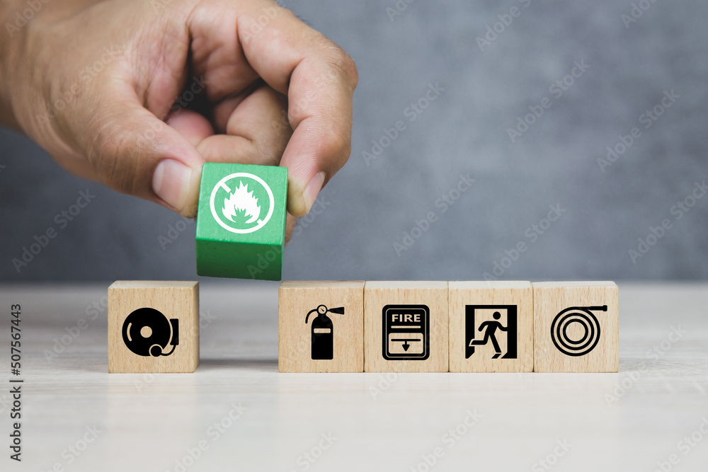 Hand choose wooden block stack with fire prevent icon and door exit ...