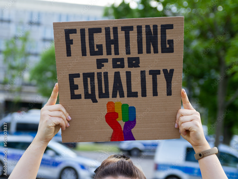 Woman holding placard sign Fighting for Equality with rainbow flag fist ...