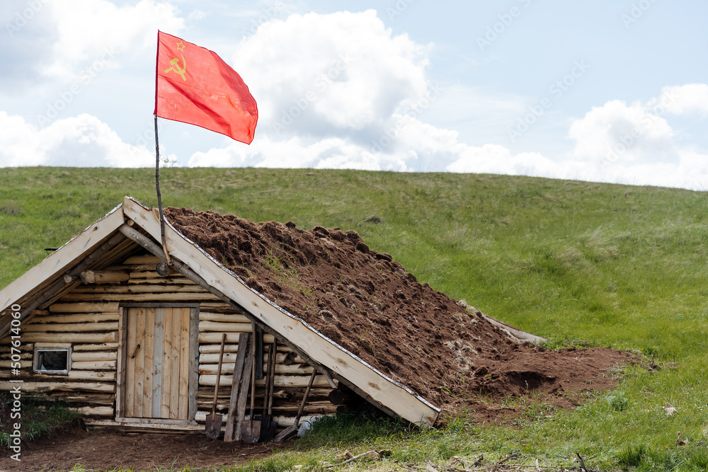 The flag of the Red Army, a military structure, an underground dugout ...