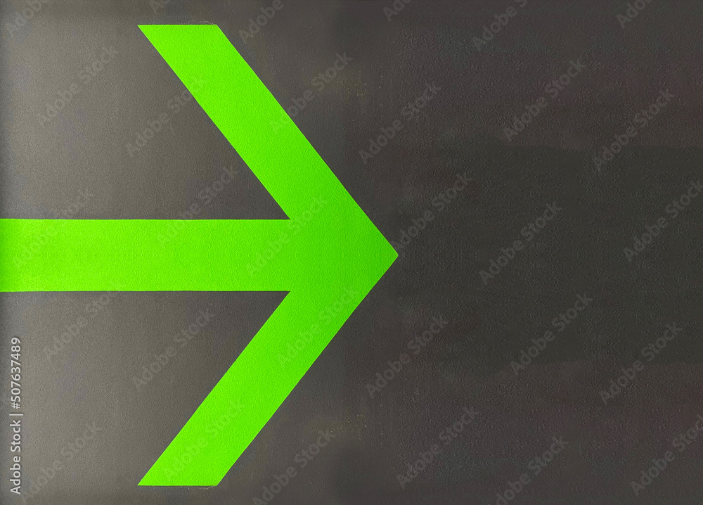 direction arrow on a black wall, green direction arrow on a black ...