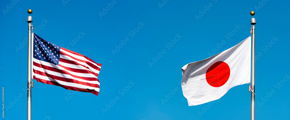 Flags of the USA and Japan against blue sky, concept political picture ...