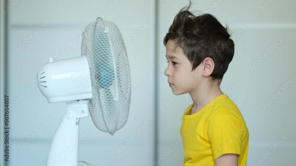 Little boy with fan relaxing at home. Summer heat. sunny hot summer day ...