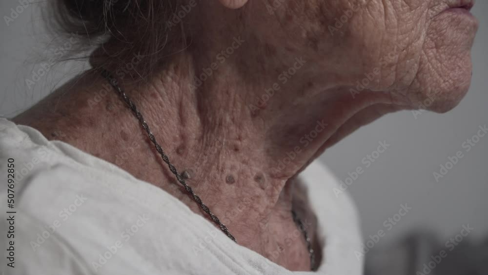 Beating of the pulse on neck of senior woman close-up. Pulsating artery ...