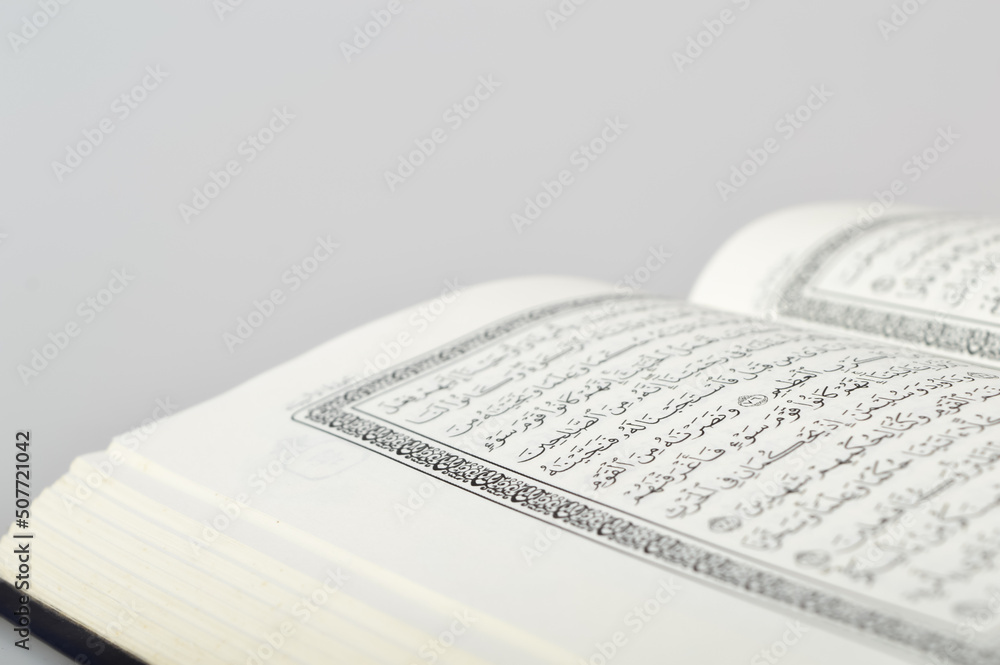 Holy Al Quran with written in arabic calligraphy isolated on a white ...
