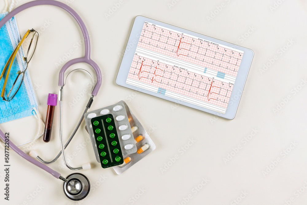 Doctor workplace an electrocardiogram with a stethoscope and mask on ...