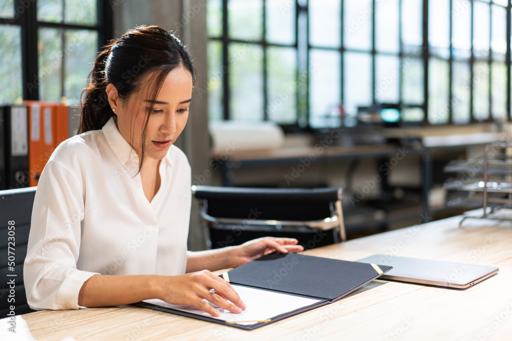 Asian business female project manager reading document report at desk ...