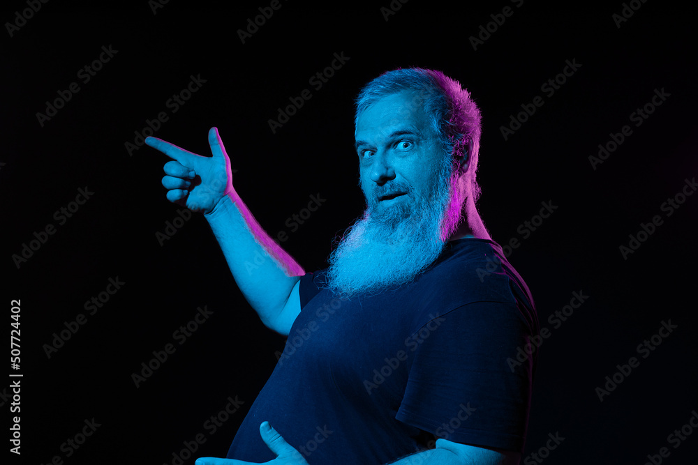 The fat man looks at the camera and shows the direction with his hands ...