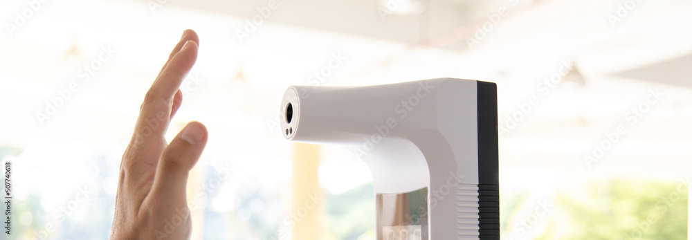 Young man used his palm to touch the sensor of the thermometer ...