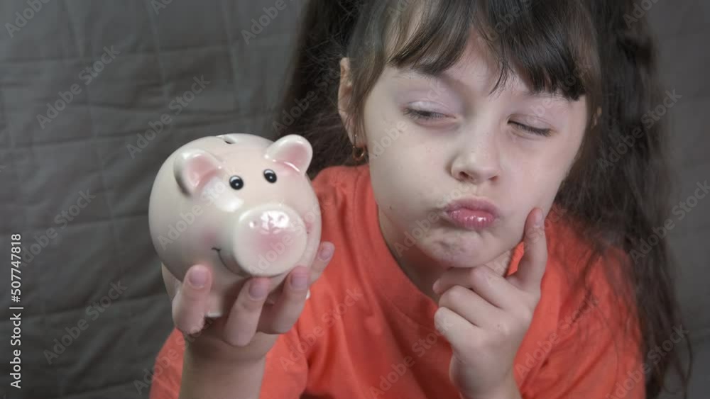 Child think about money. A young child think about piggy bank finance ...