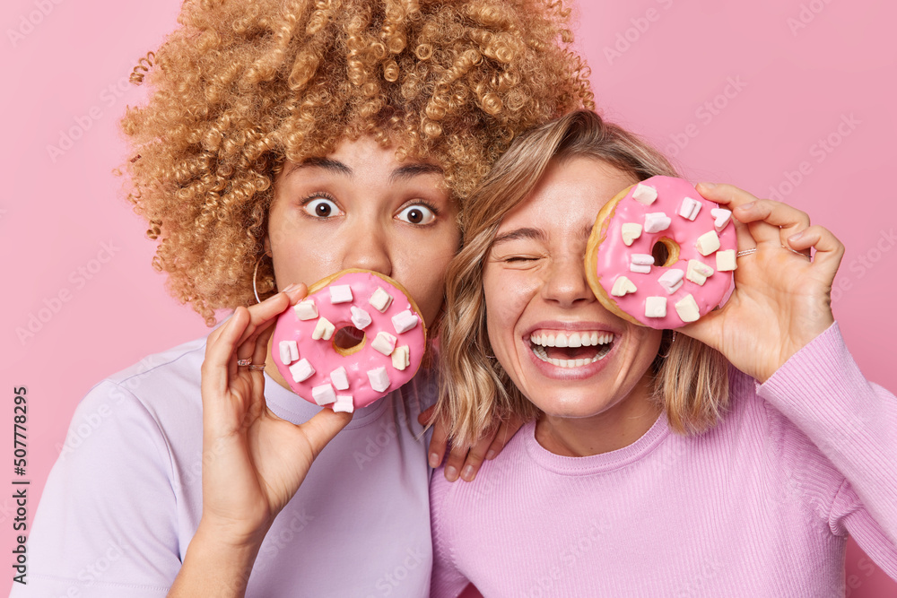 Photo of two female best friends hold delicious doughnuts with ...
