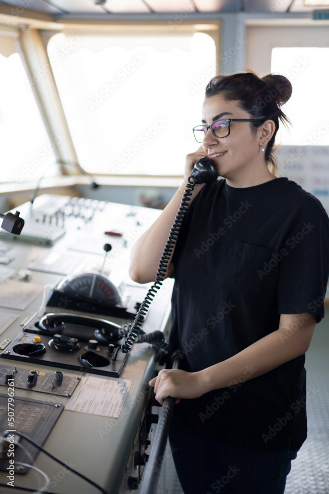 Young and beautiful ship captain wearing glasses talking on phone in ...