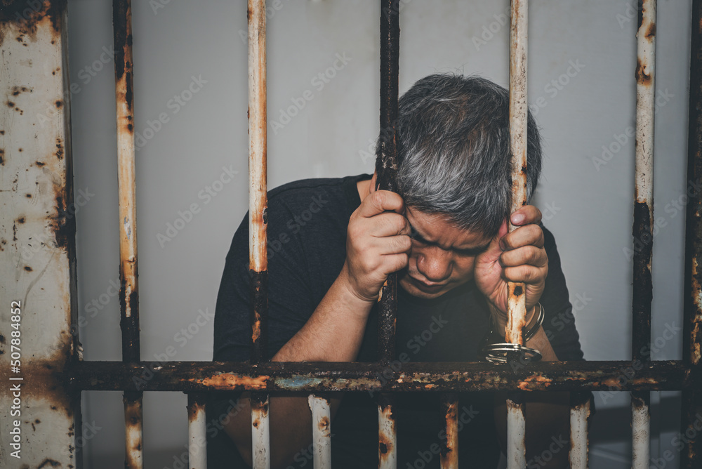 Asian male criminals was arrested and handcuffed in a dirty cage ...