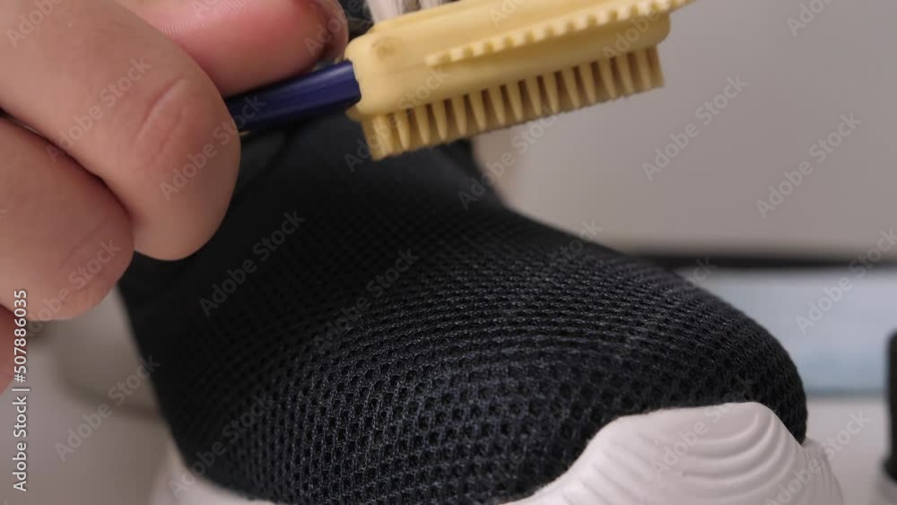 Cleaning a sneaker with a shoe care brush. close-up slow motion Stock ...