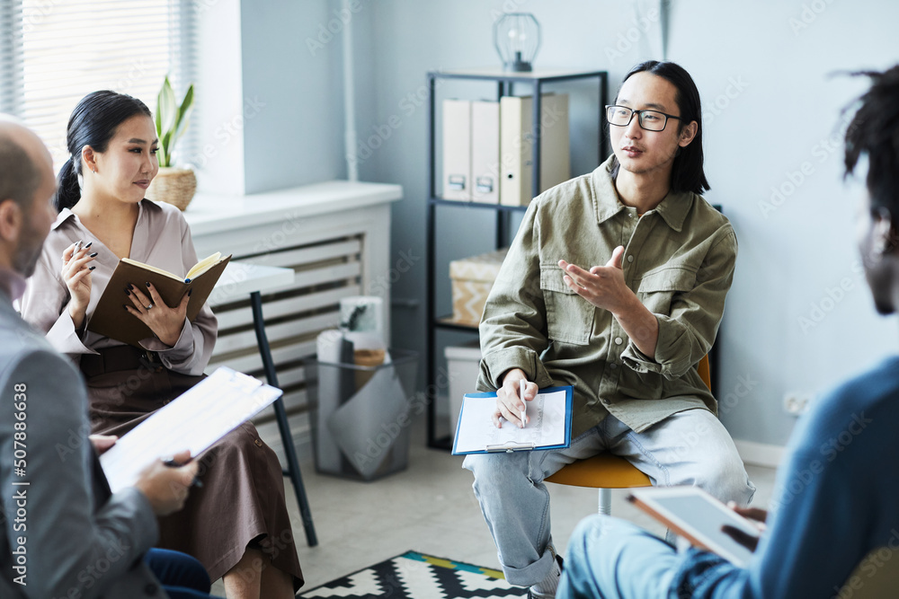 Portrait of young Asian man asking audience during English lesson with ...
