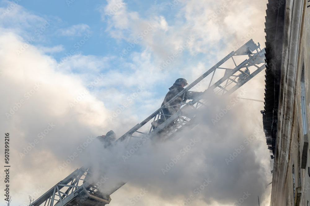 Firefighter works on boom of fire engine. Fireman on sky background ...