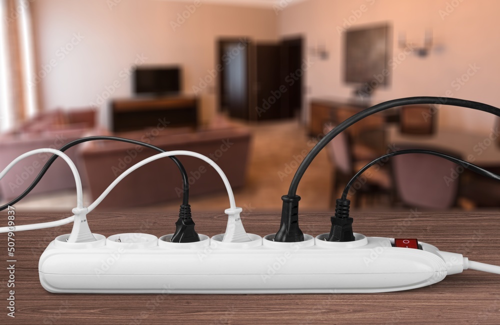 Unplugged electric appliance plug over switched off white power strip ...