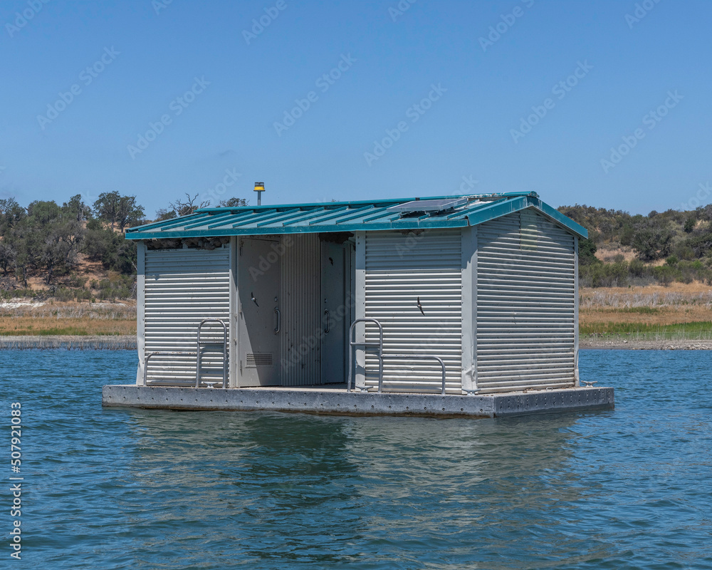 A Public floating restroom on a lake. Cliff swallows have built nests ...