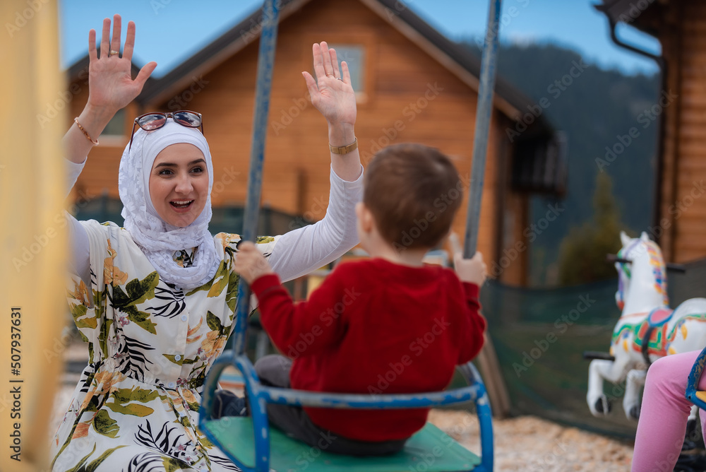 A happy Muslim family is having fun in the park smiling mother in a ...
