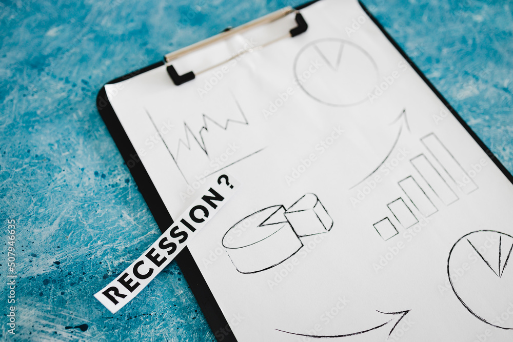 recession text next to clipboard showing a multitude of stas and graphs ...