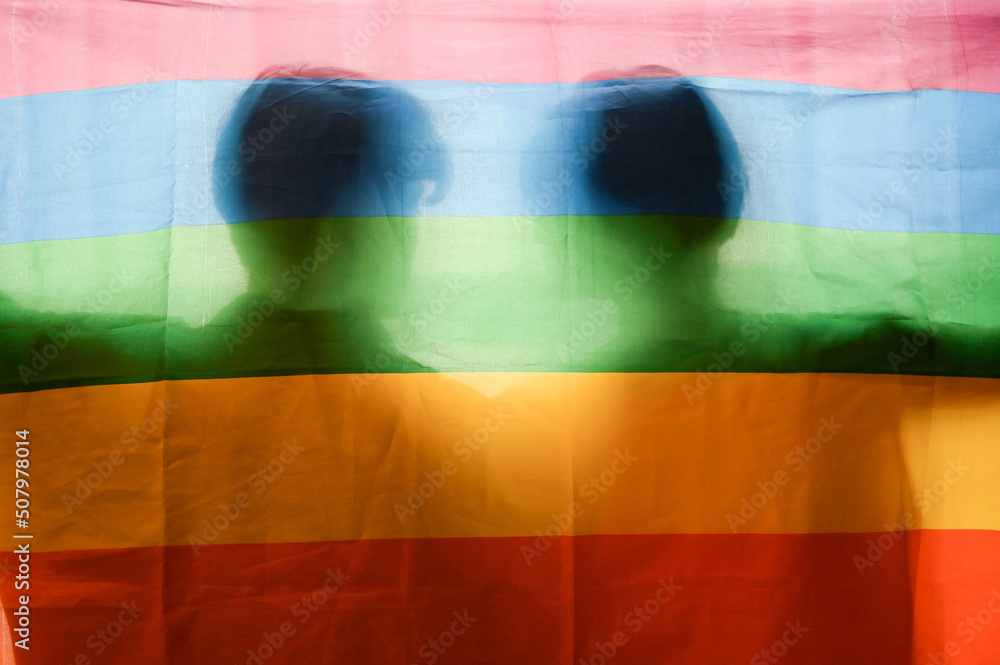 Rainbow flag background with a shadow of men behind. LGBT pride, LGBT ...