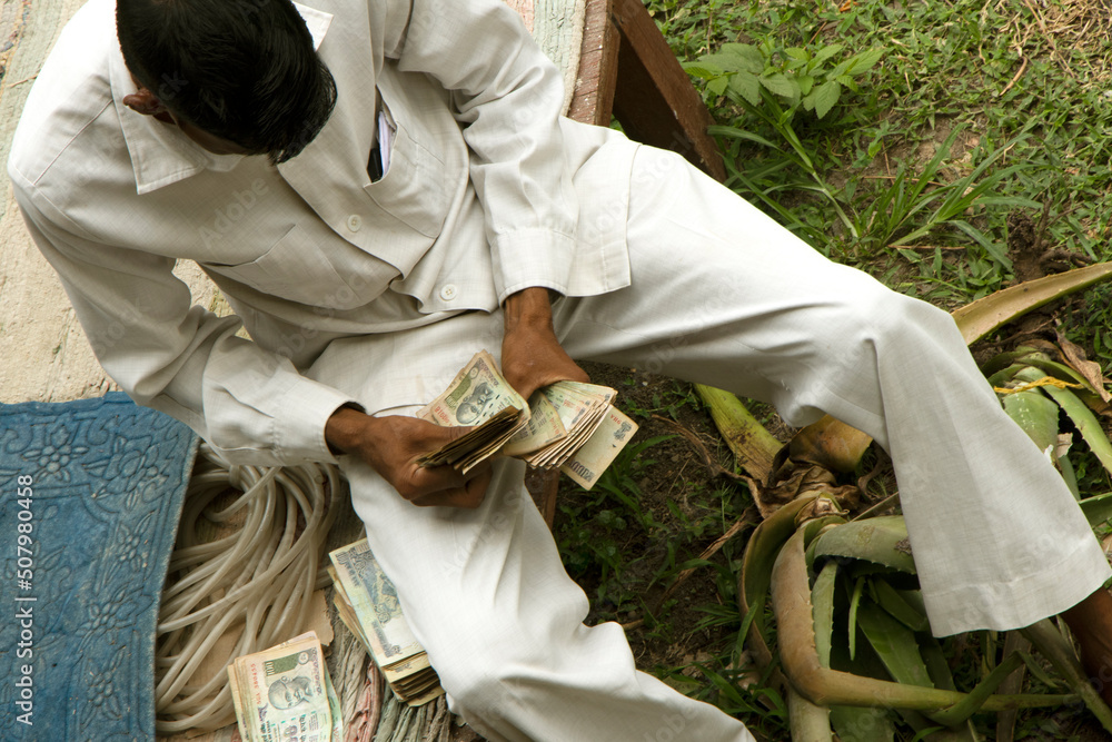 man counting Indian currency notes with his hand Stock Photo | Adobe Stock