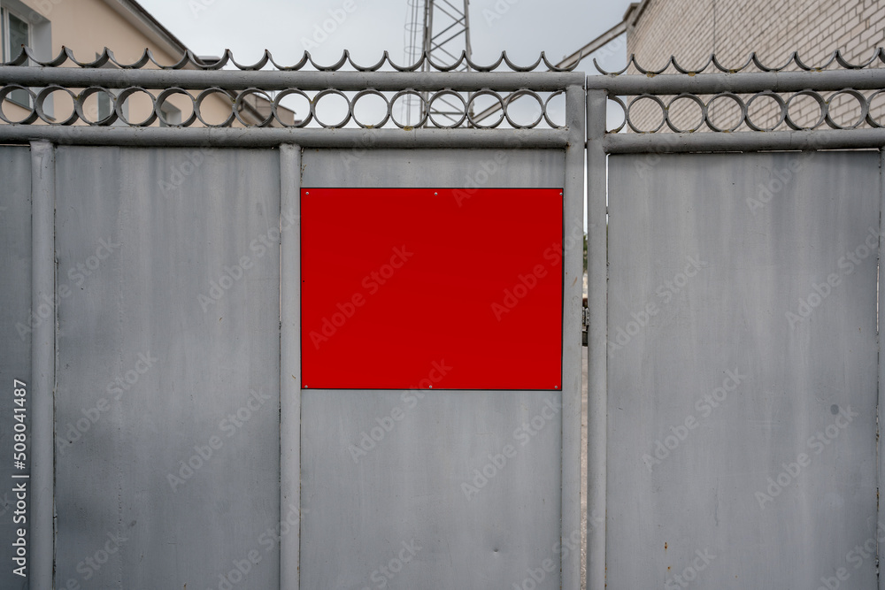 Blank red sign board with mockup space mounted on iron gate of private ...