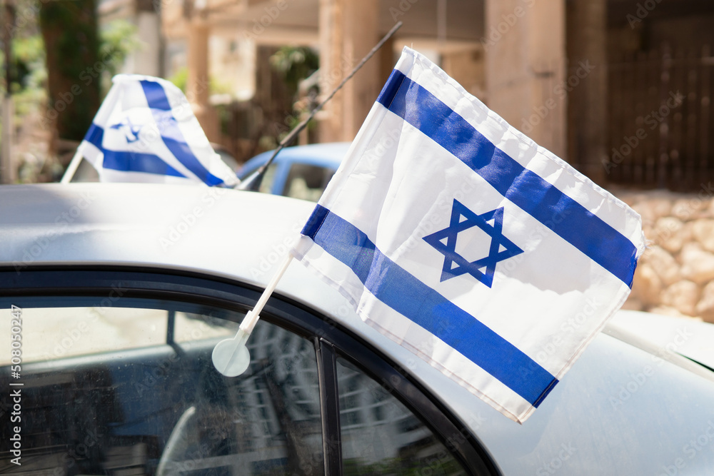 Israel flags waving in the wind attached to the car window outdoors ...
