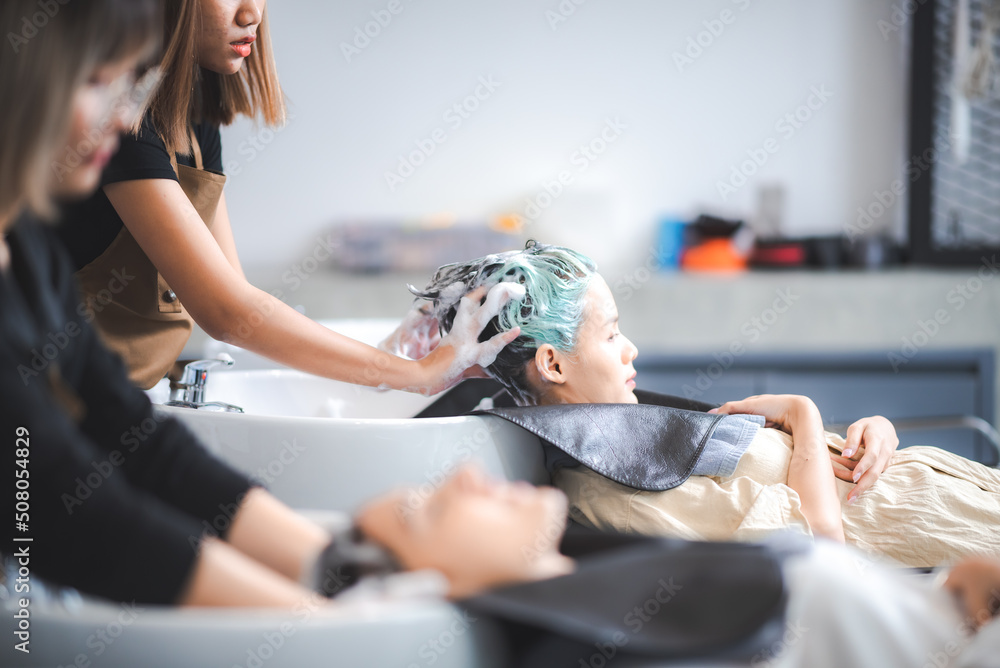 professional hairdresser woman are washing client hair in beauty salon ...
