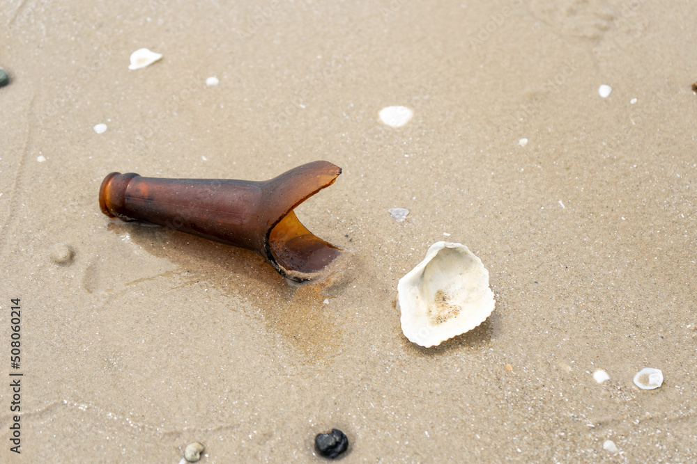 broken glass bottle on the beach. sharp hazardous waste. marine ...