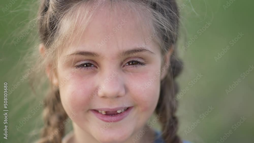 Cute happy child is play in park in nature. Smiling cheerful girl at ...