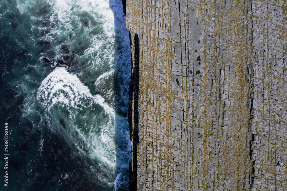 Ocean waves hit cliffs. Rough stone coastline of Aran island, county ...