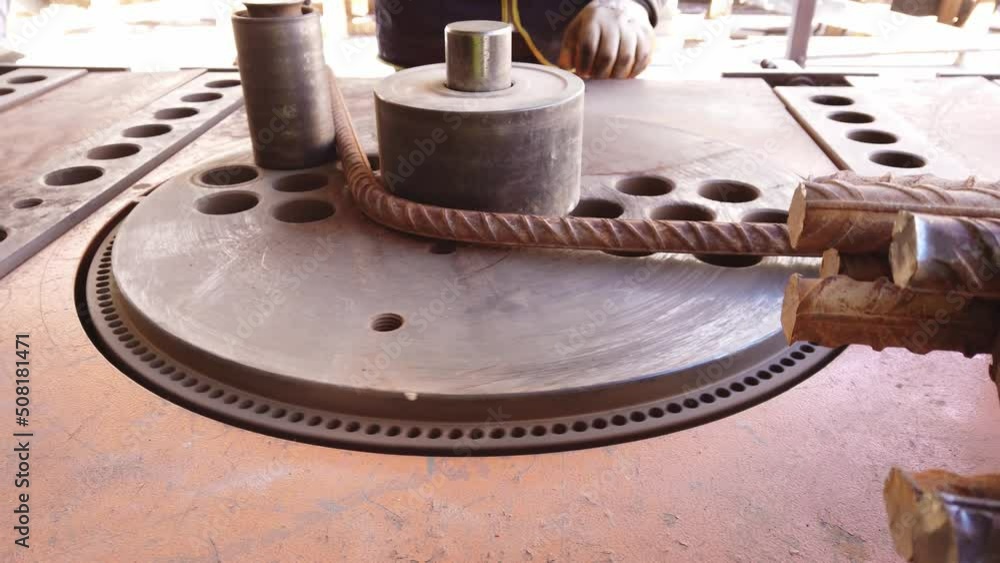 Construction worker bends metal reinforcing rebar with industrial ...