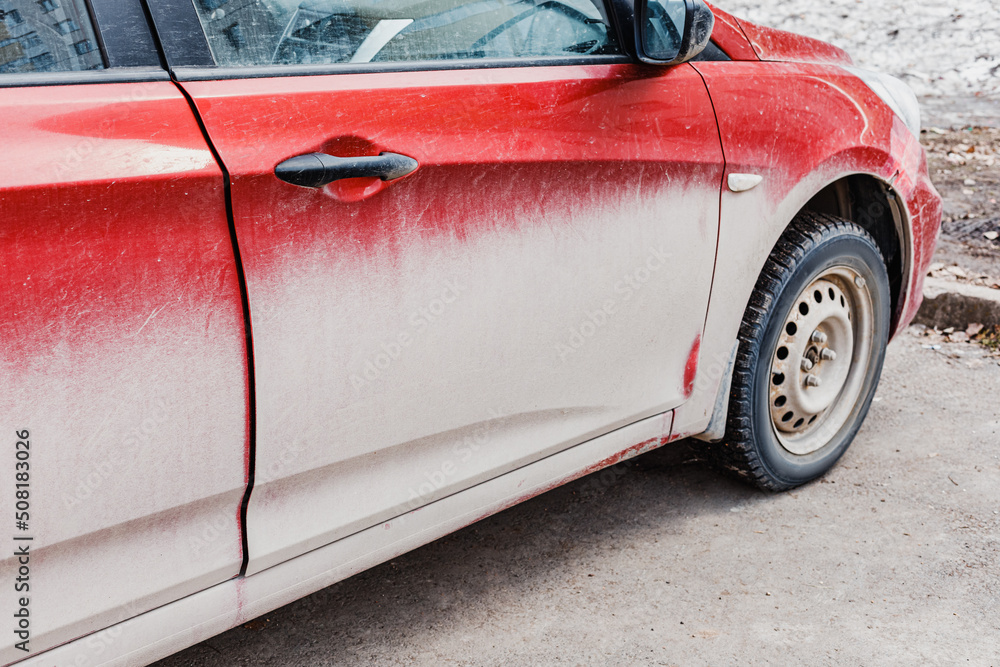 An unwashed and soiled battered car in the spring. The concept of road ...