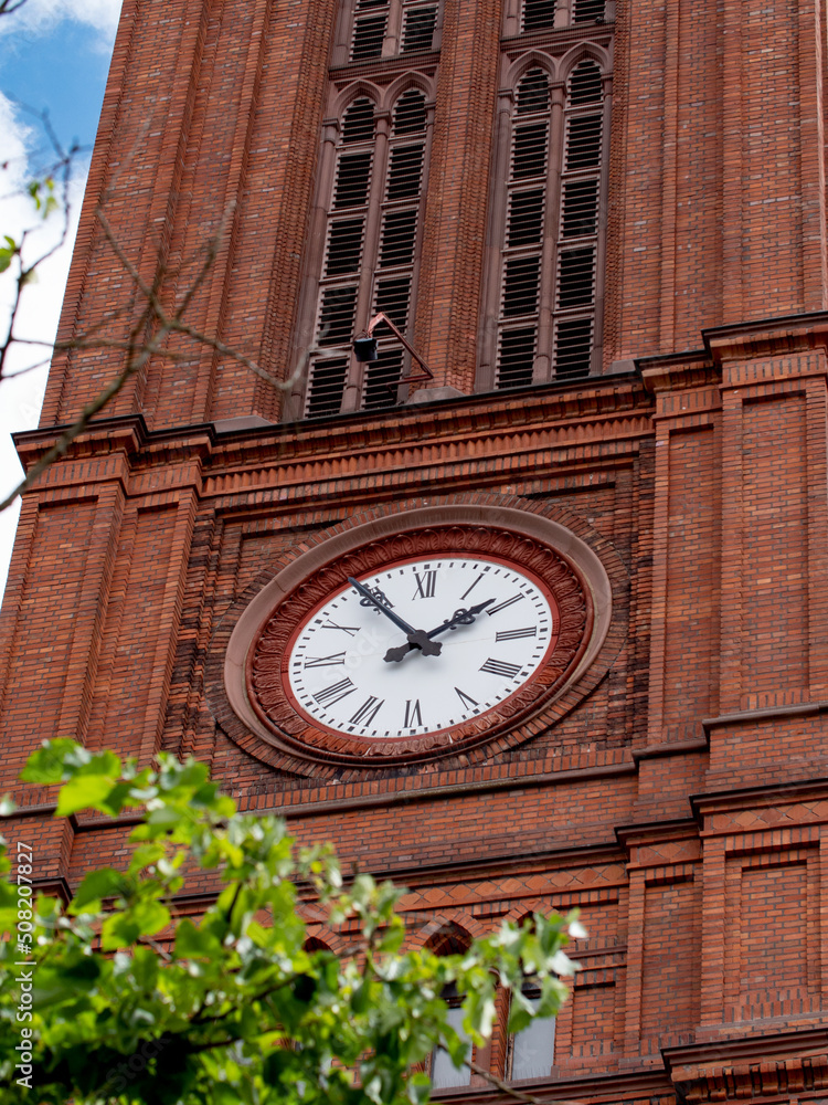 Church clock. Red brick church tower with ancient black and white clock ...