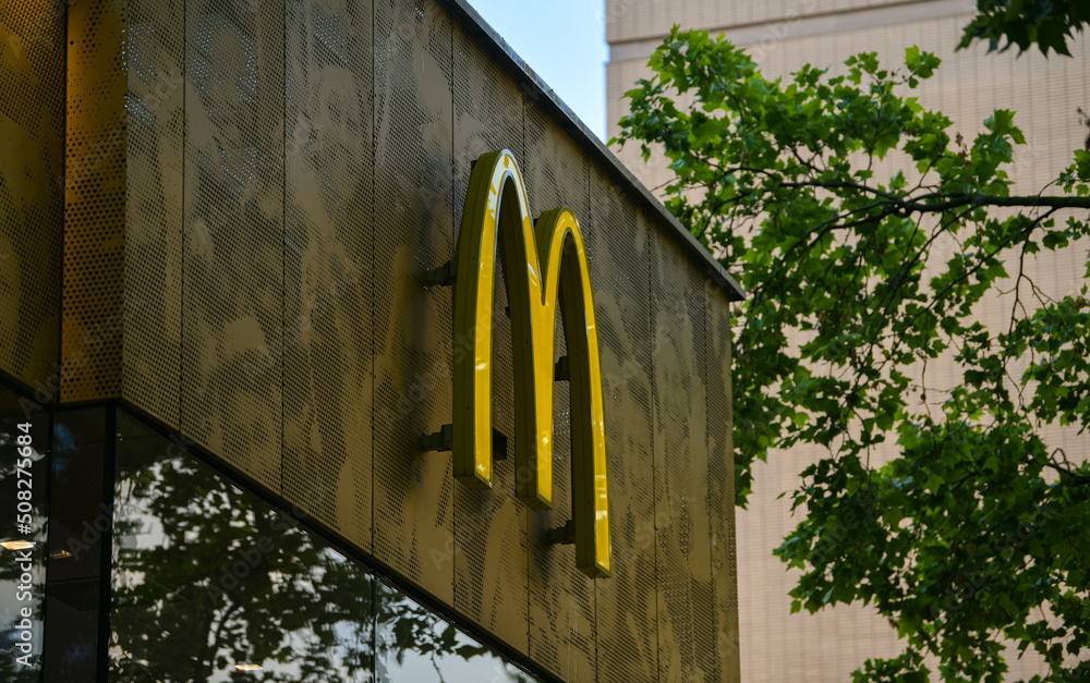 The logo sign of McDonalds American fast-food chain on top of a ...