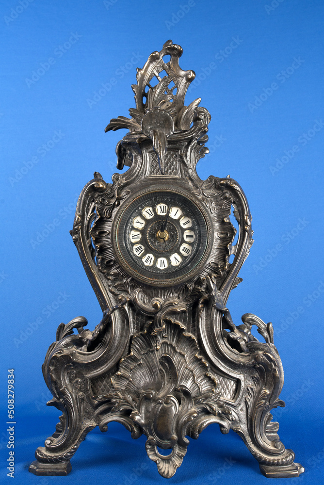 vintage bronze watch on a blue background, bronze fireplace clock, dark ...