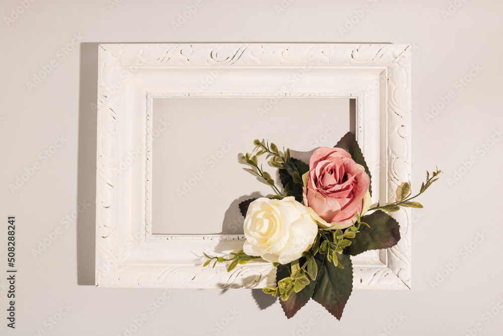 White and pink roses in vintage painting frame on light background ...