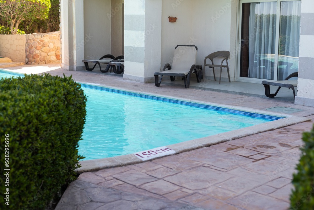 Swimming pool with clean clear water, nobody. Square shaped pool with ...