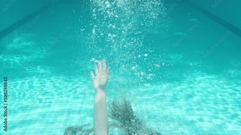 Blue swimming pool, underwater shooting, sunny day. Chubby girl drowns ...