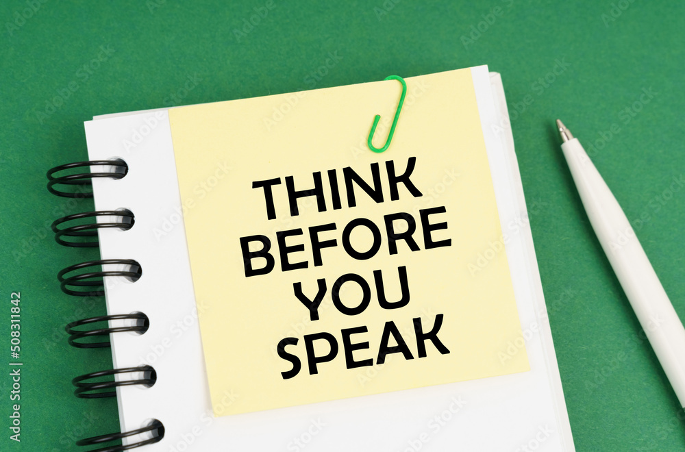 On a green surface, a pen, a notepad with stickers and the inscription ...