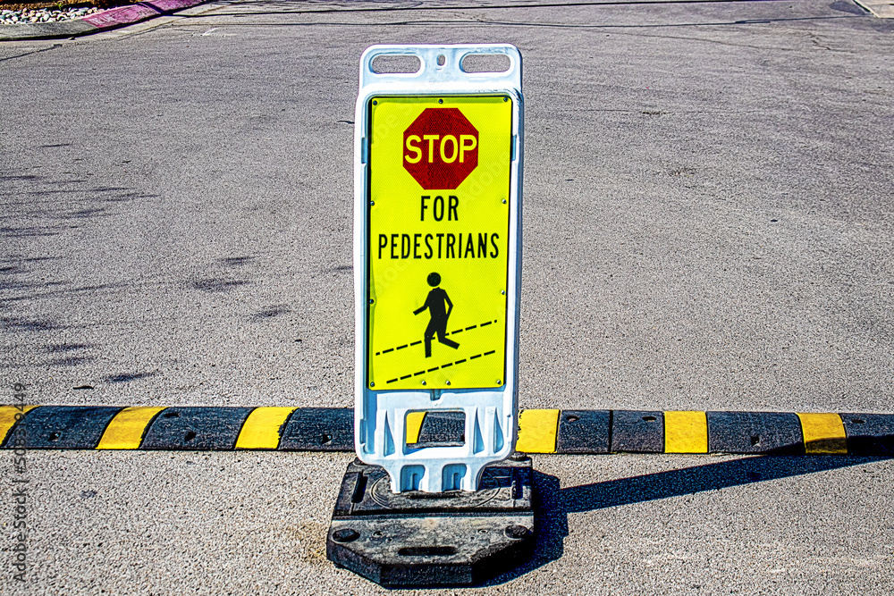 Weighted stand-up Stop for Pedestrians sign in grainy concrete parking ...
