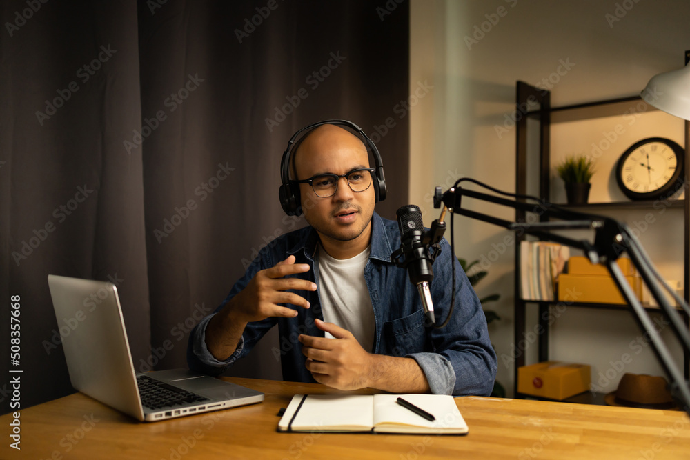 Young asian man host streaming podcast with condenser microphone work ...