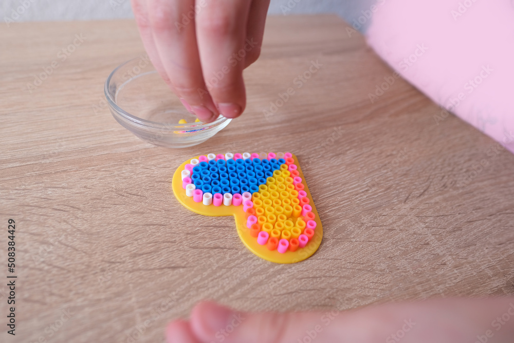 close-up of heart, children's hands creating perler bead patterns, make ...