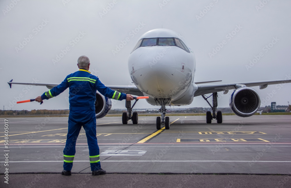 An airliner is taxiing into a parking lot at an airport, an air ...