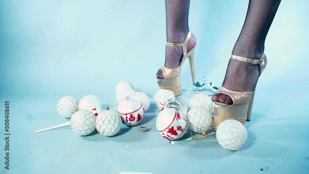 A woman's leg in fishnet tights smashes a Christmas toy with a heel ...