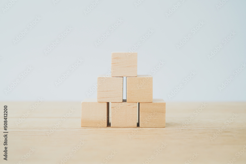 pyramid blank wooden block isolated on desk with blue background for graphic resource element of ...